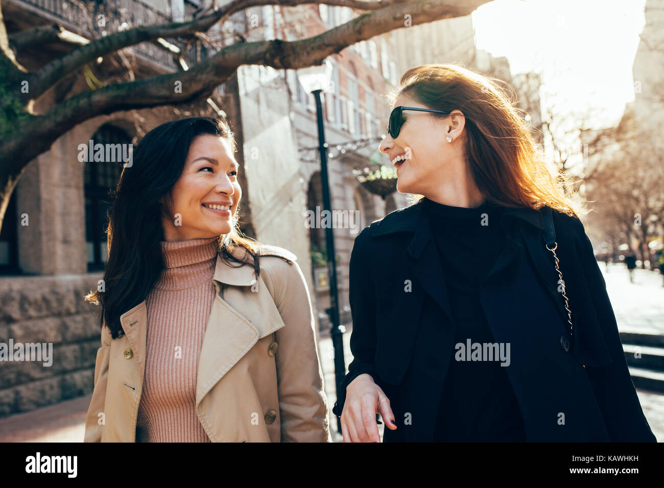 Two women outdoors having fun. Female friends on walking down the ...