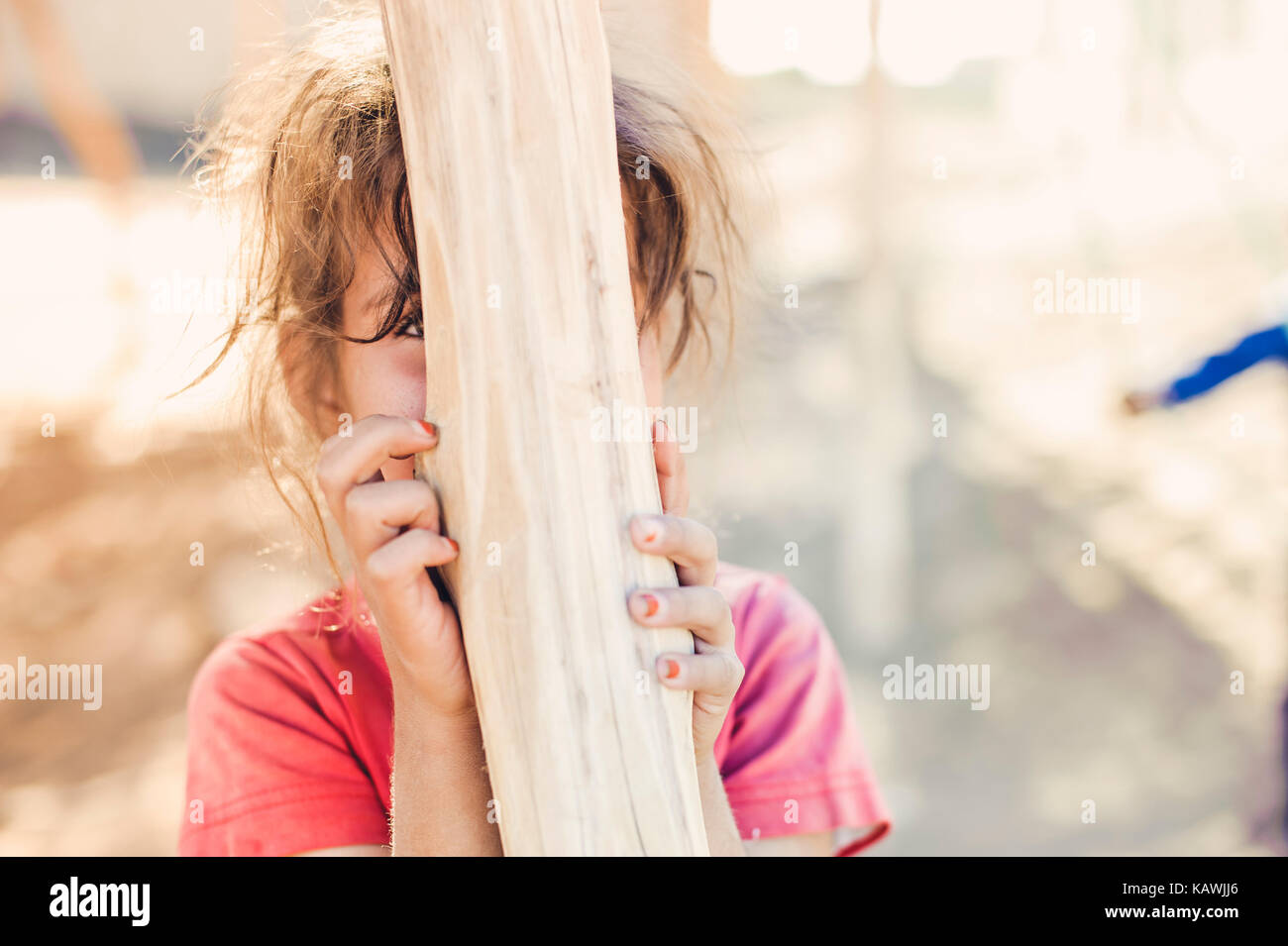 The girl hides behind a wooden pole Stock Photo - Alamy