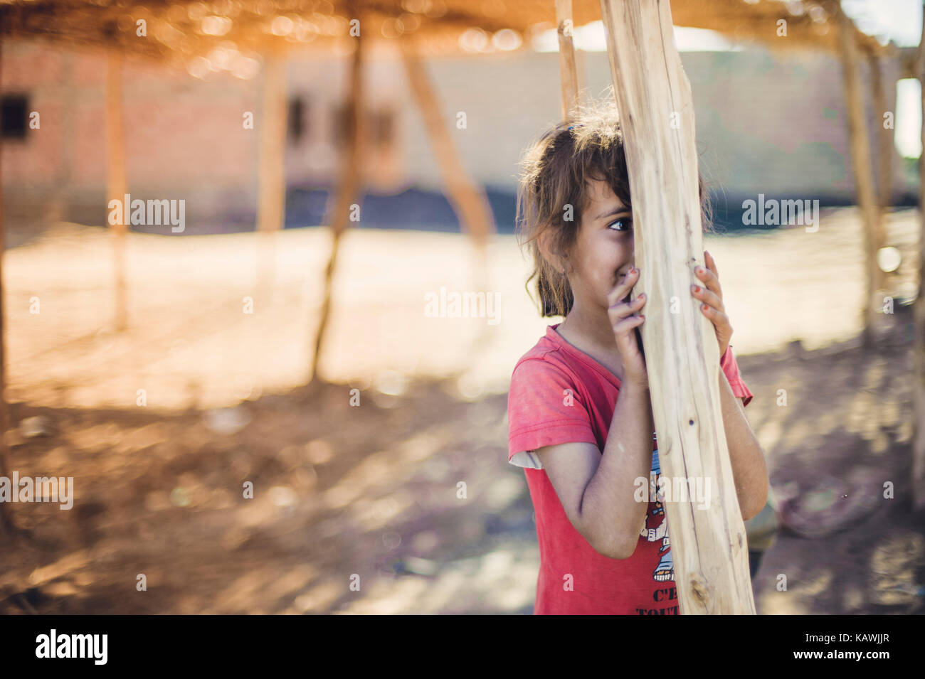 The girl hides behind a wooden pole Stock Photo - Alamy