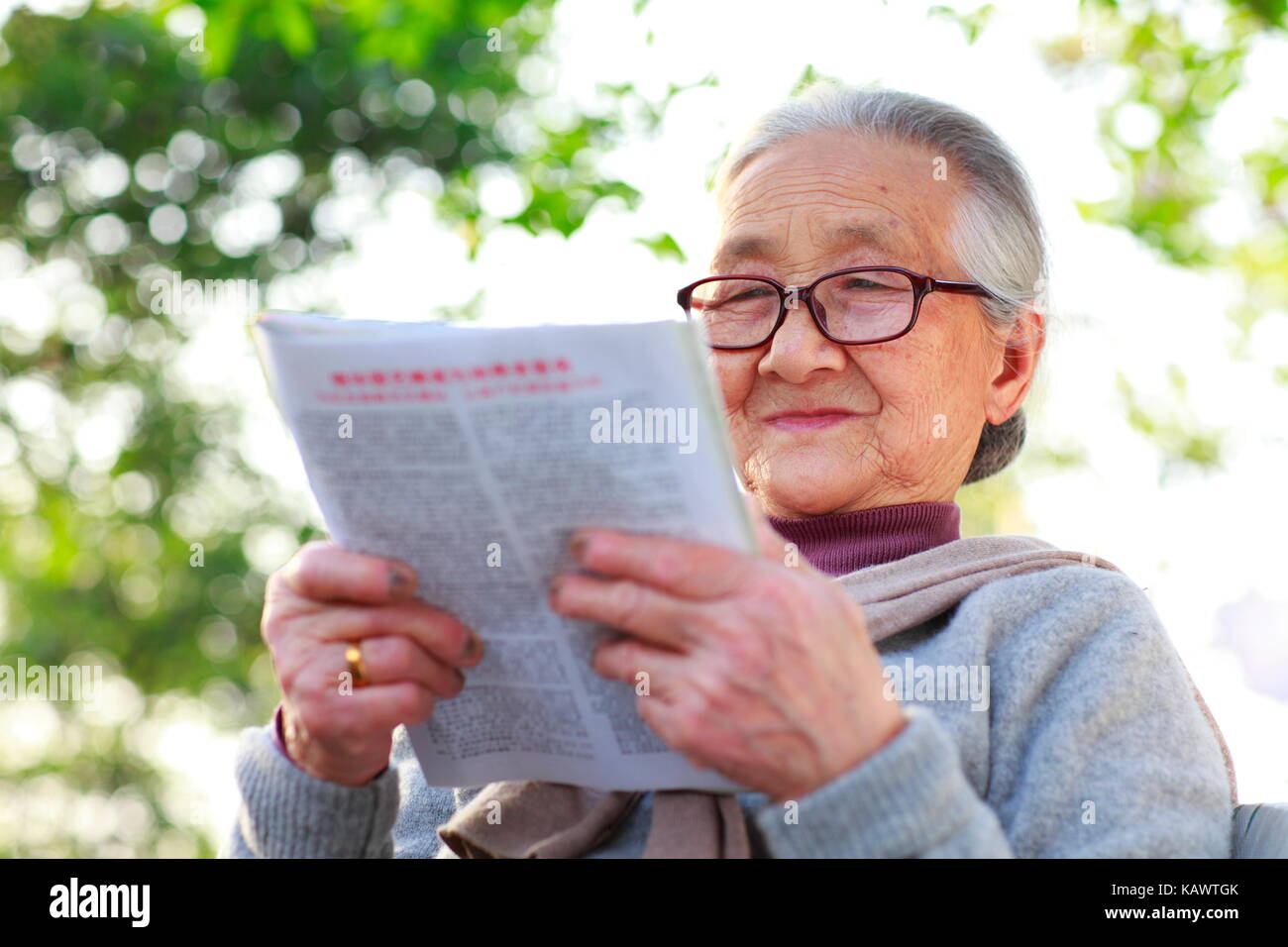 One happy Senior Chinese woman reading book in the yard Stock Photo - Alamy