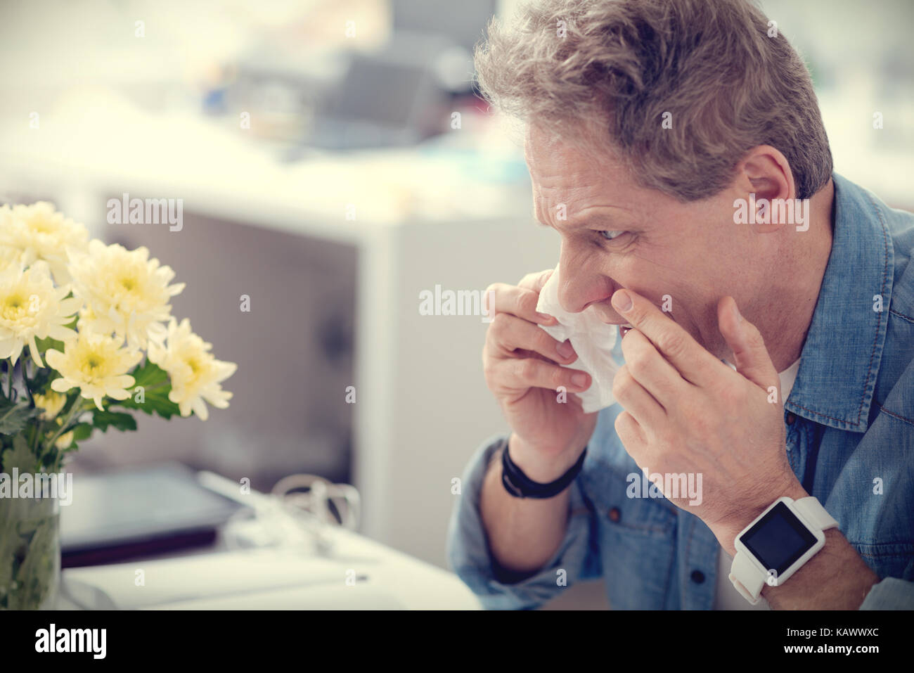 Moody cheerless man having a running nose Stock Photo - Alamy