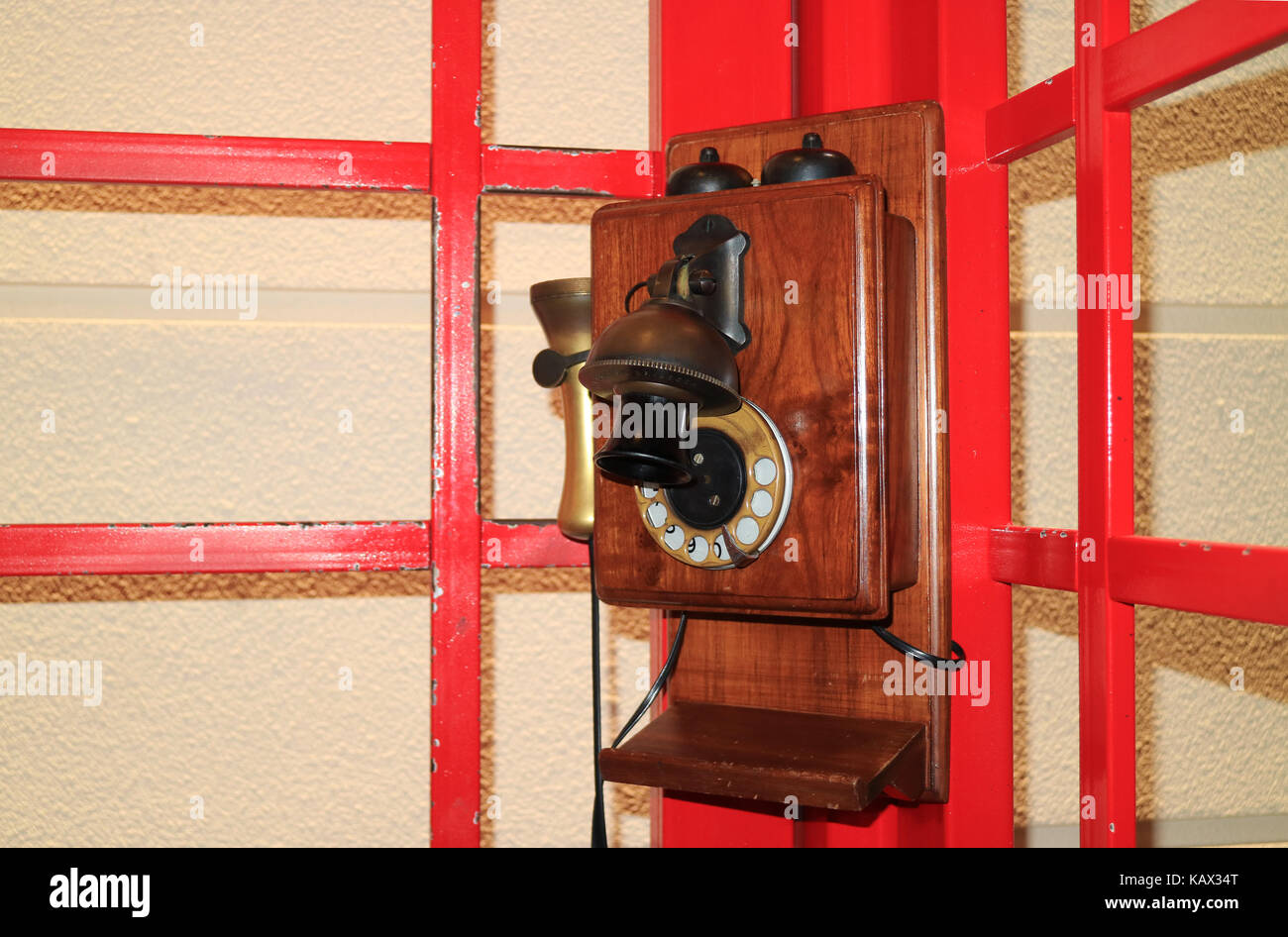 Vintage style wooden public telephone in the red colored telephone ...