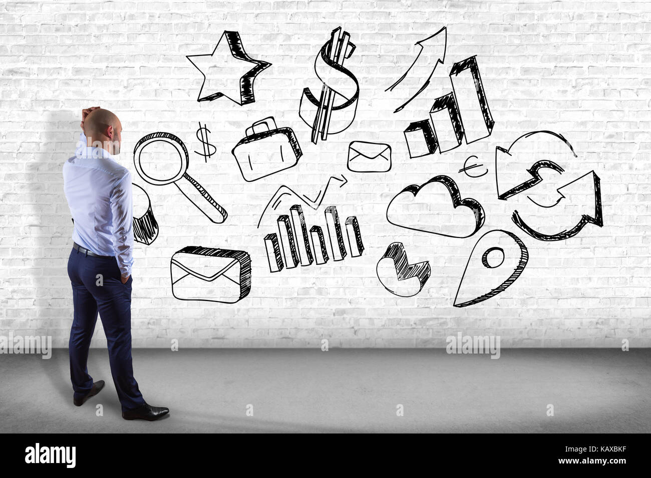 View of a Businessman in front of a wall thinking about a hand drawn ...