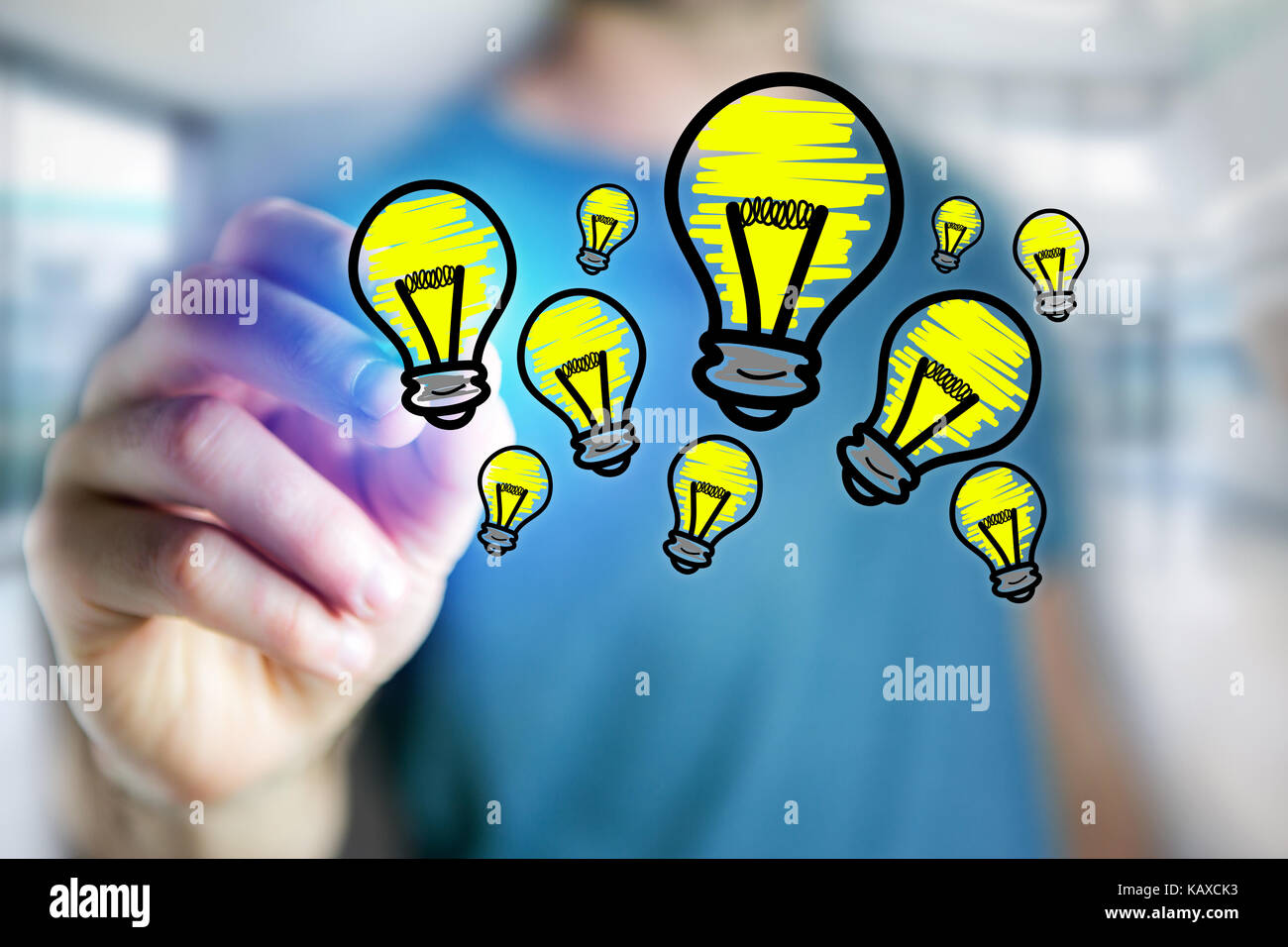 View of Man hand drawing bulb lamp icon on a futuristic interface ...