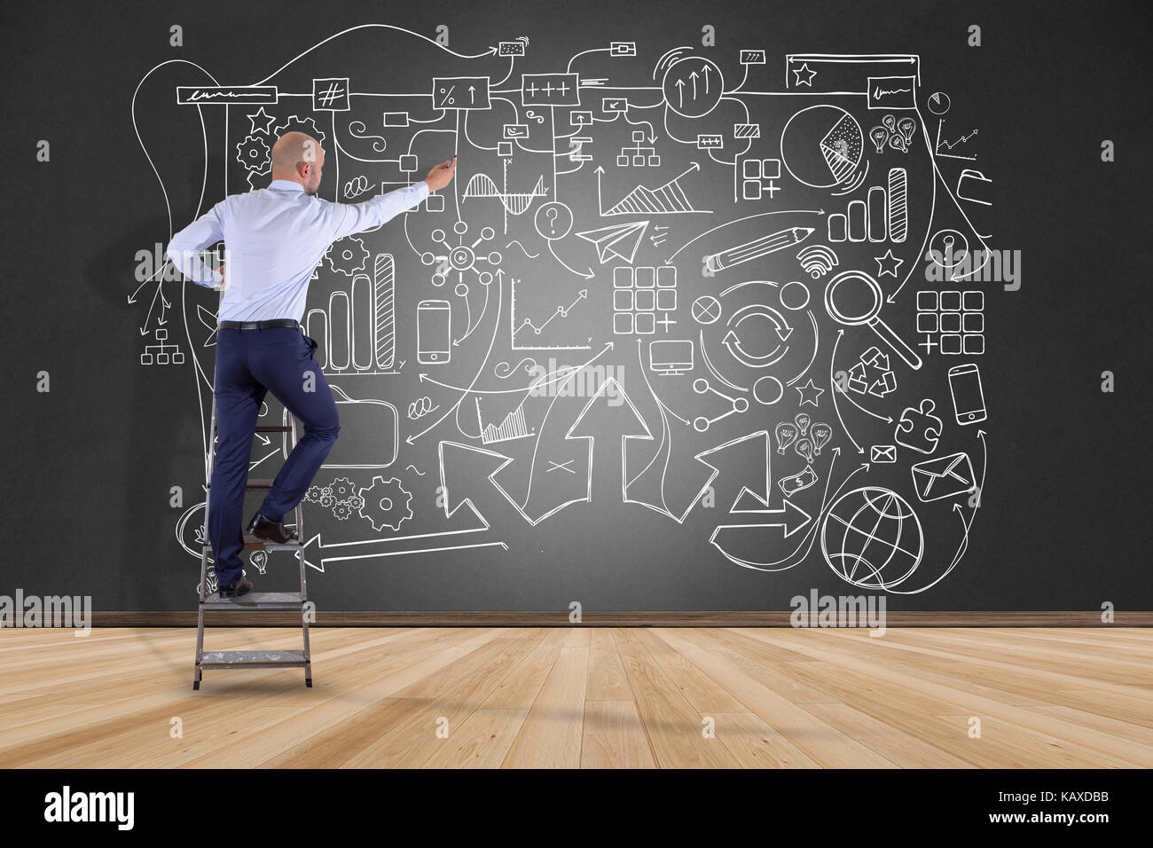 View of a Businessman drawing a hand drawn Complex schema on a wall ...