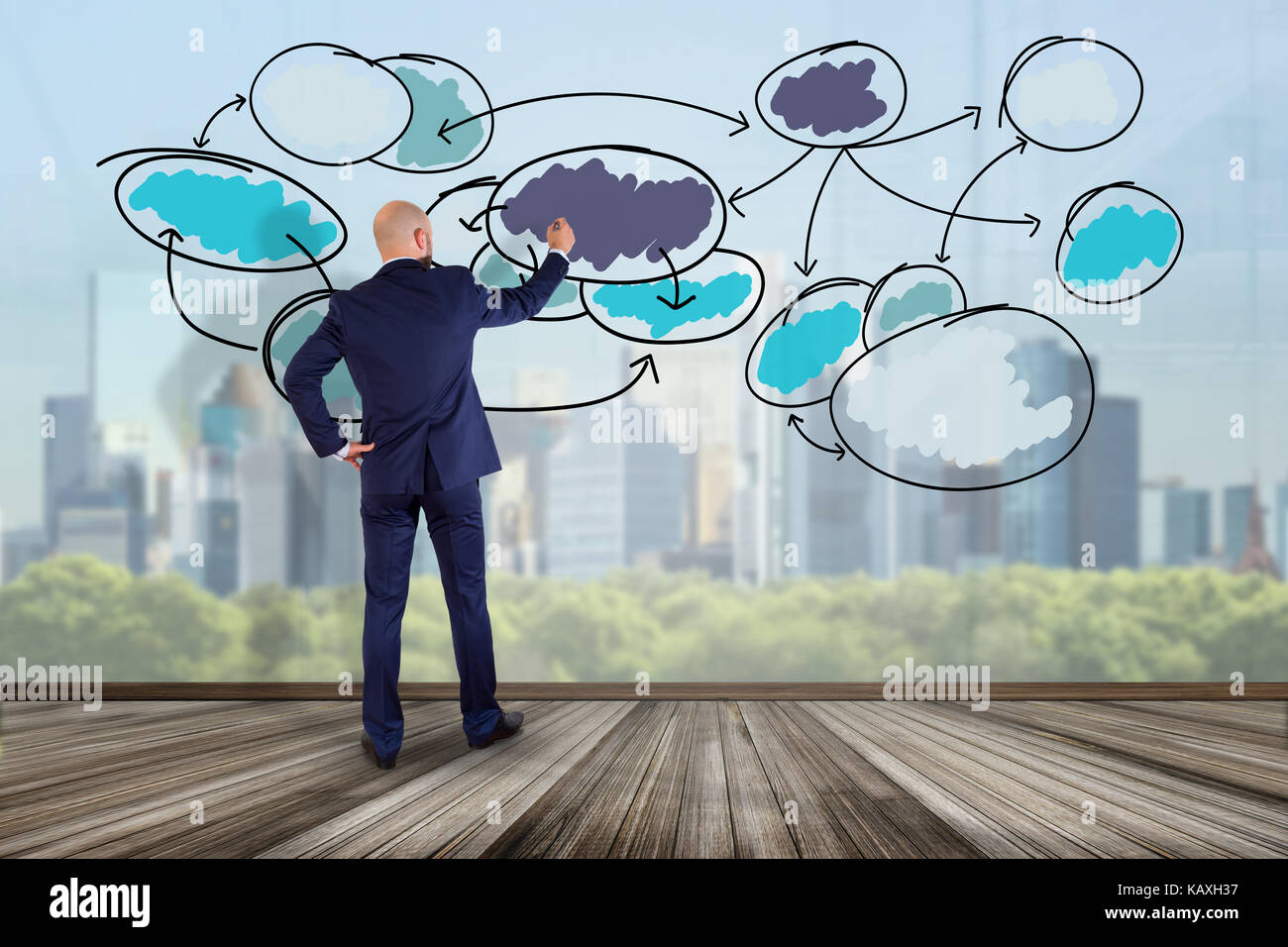 View of a Businessman in front of a wall writing on a business chart ...