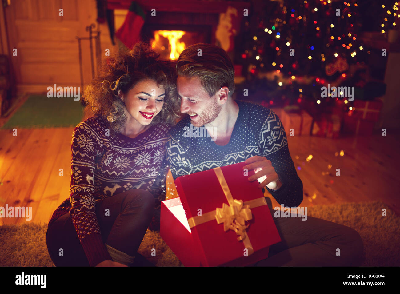 Happy couple looking at magical present in box Stock Photo - Alamy