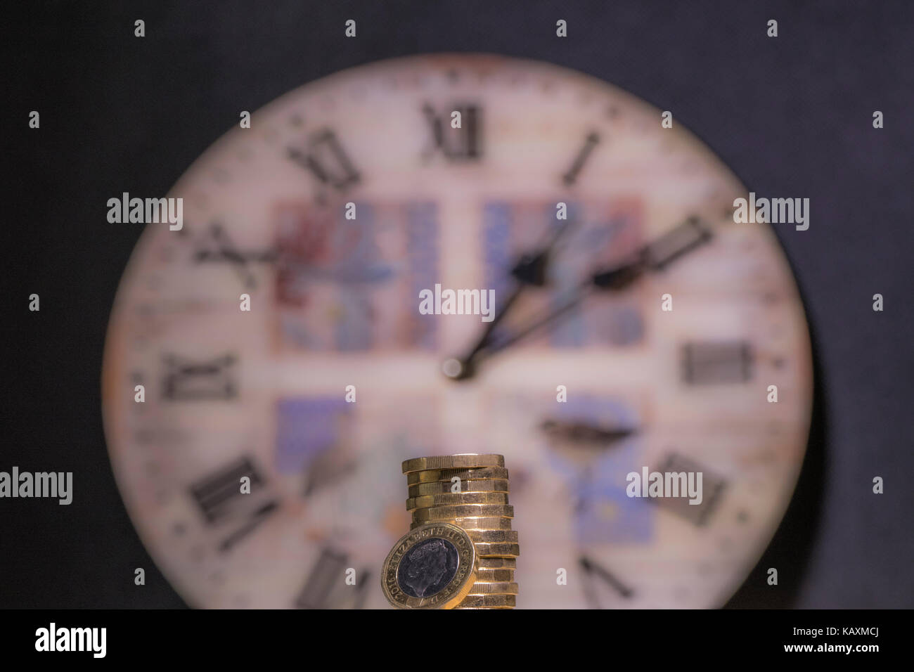 Defocused clock with new pound coins. General concept of the link ...
