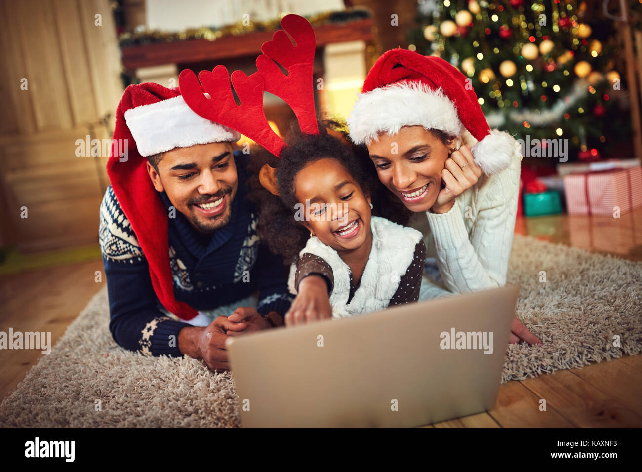 lovely family sharing laptop near the Christmas tree on a winter ...