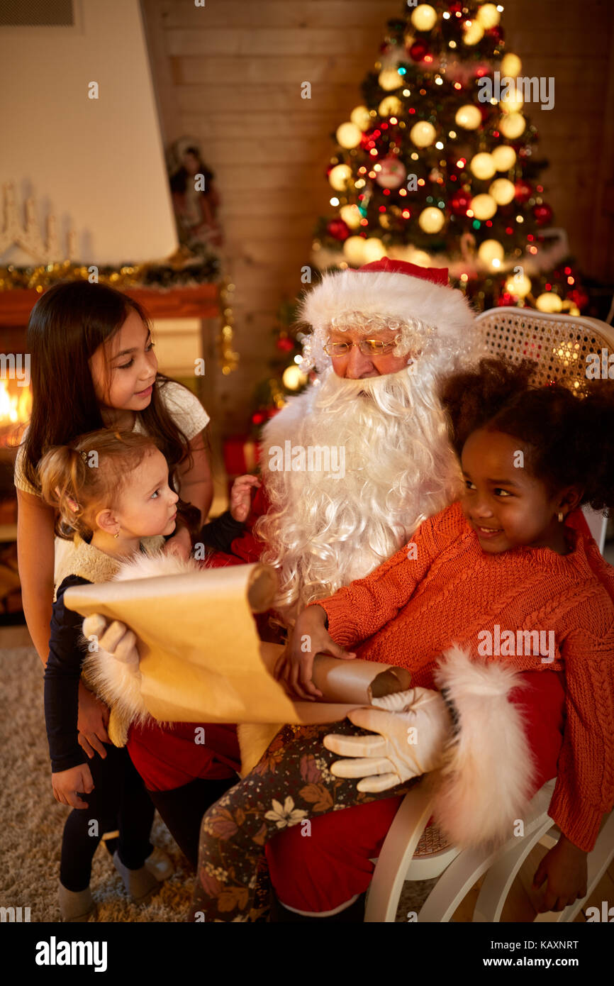 Real Christmas father checking wish list surrounded with three cute ...
