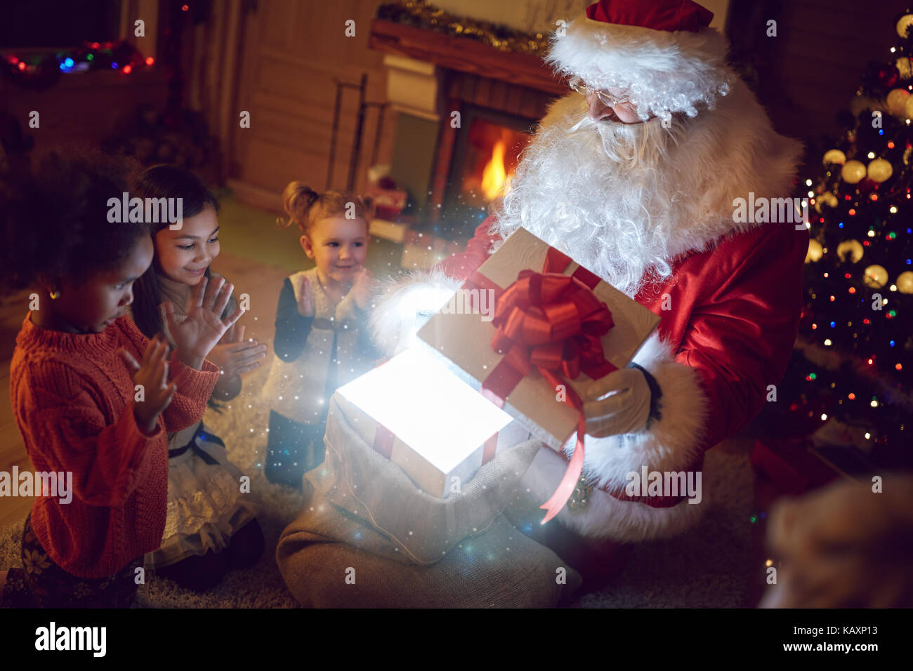 Traditional Santa Claus with children and magical present, open gift ...