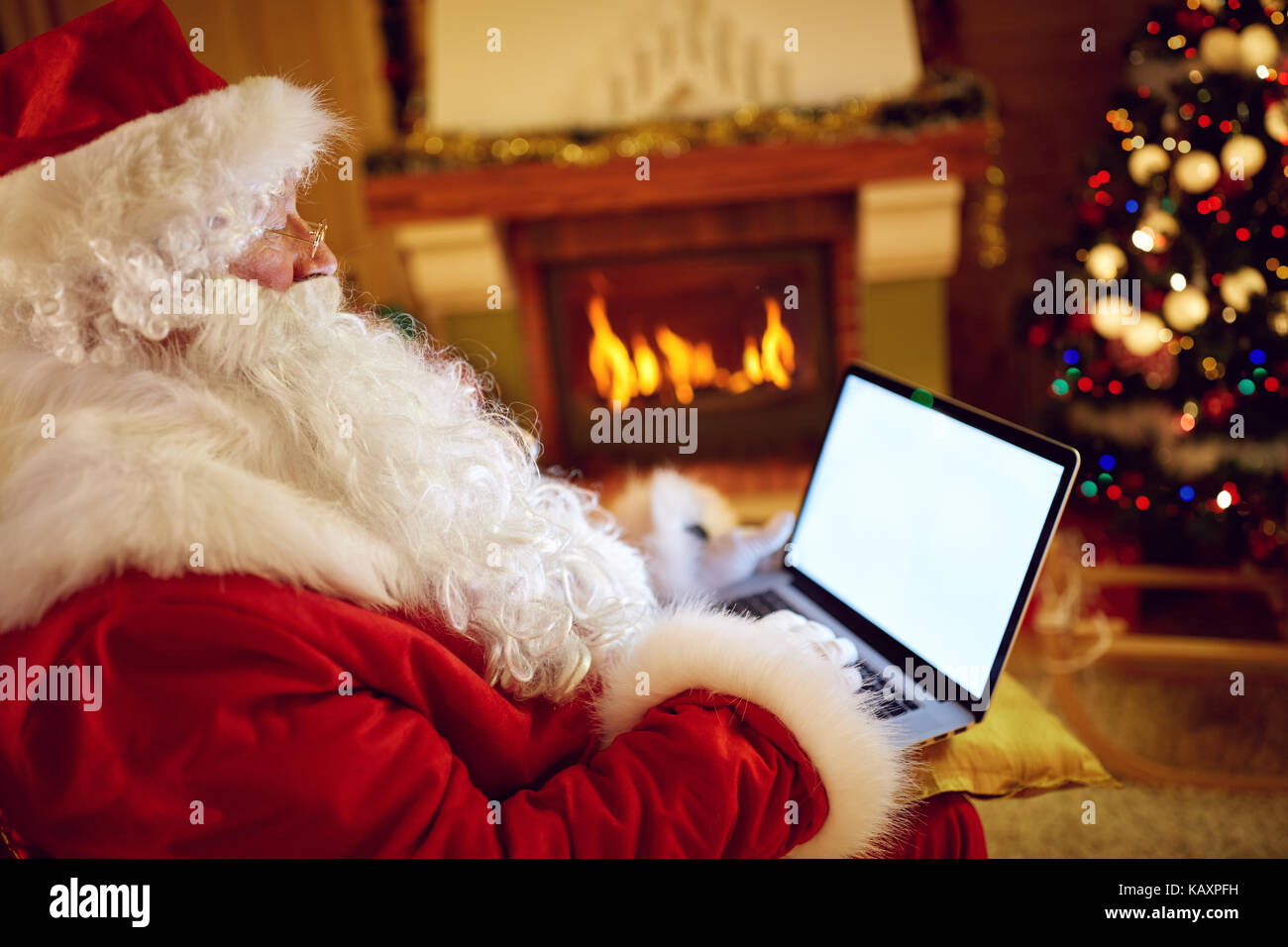 Santa Claus reading email on laptop with Christmas requesting or wish ...