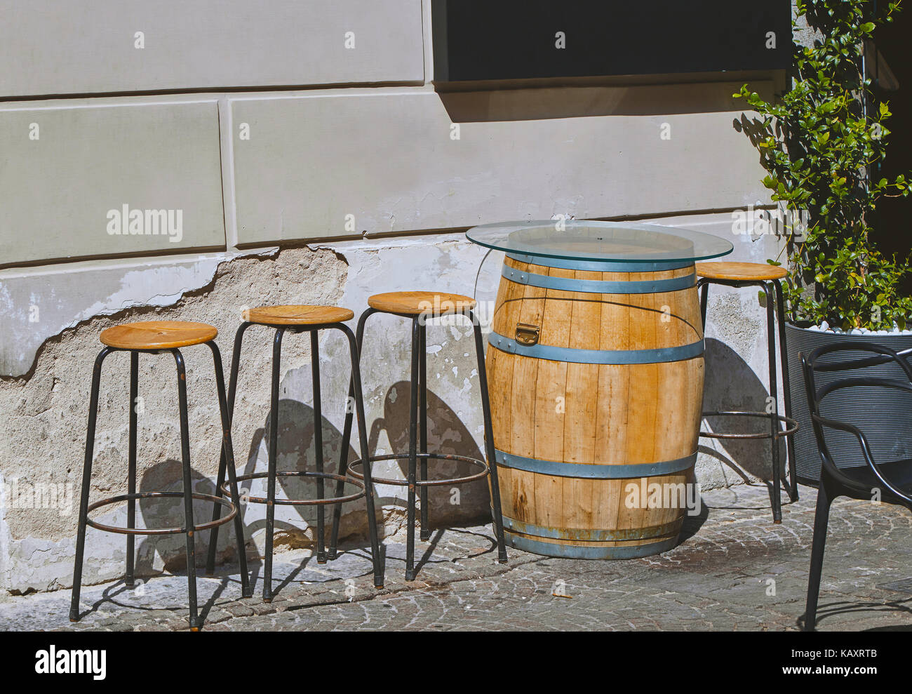 A small street cafe in Italy with three chairs and a barrel table Stock ...