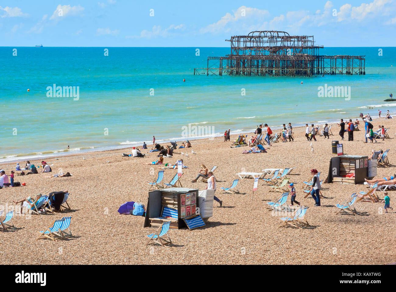 Beachgoers enjoy the sun in Brighton, with fire-damaged Brighton's West ...