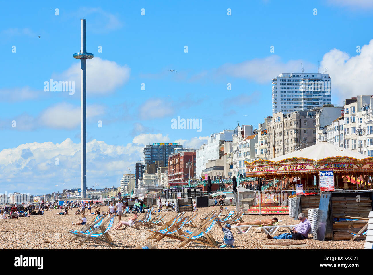Beachgoers enjoy the sun in Brighton, with British Airways i360 viewing ...