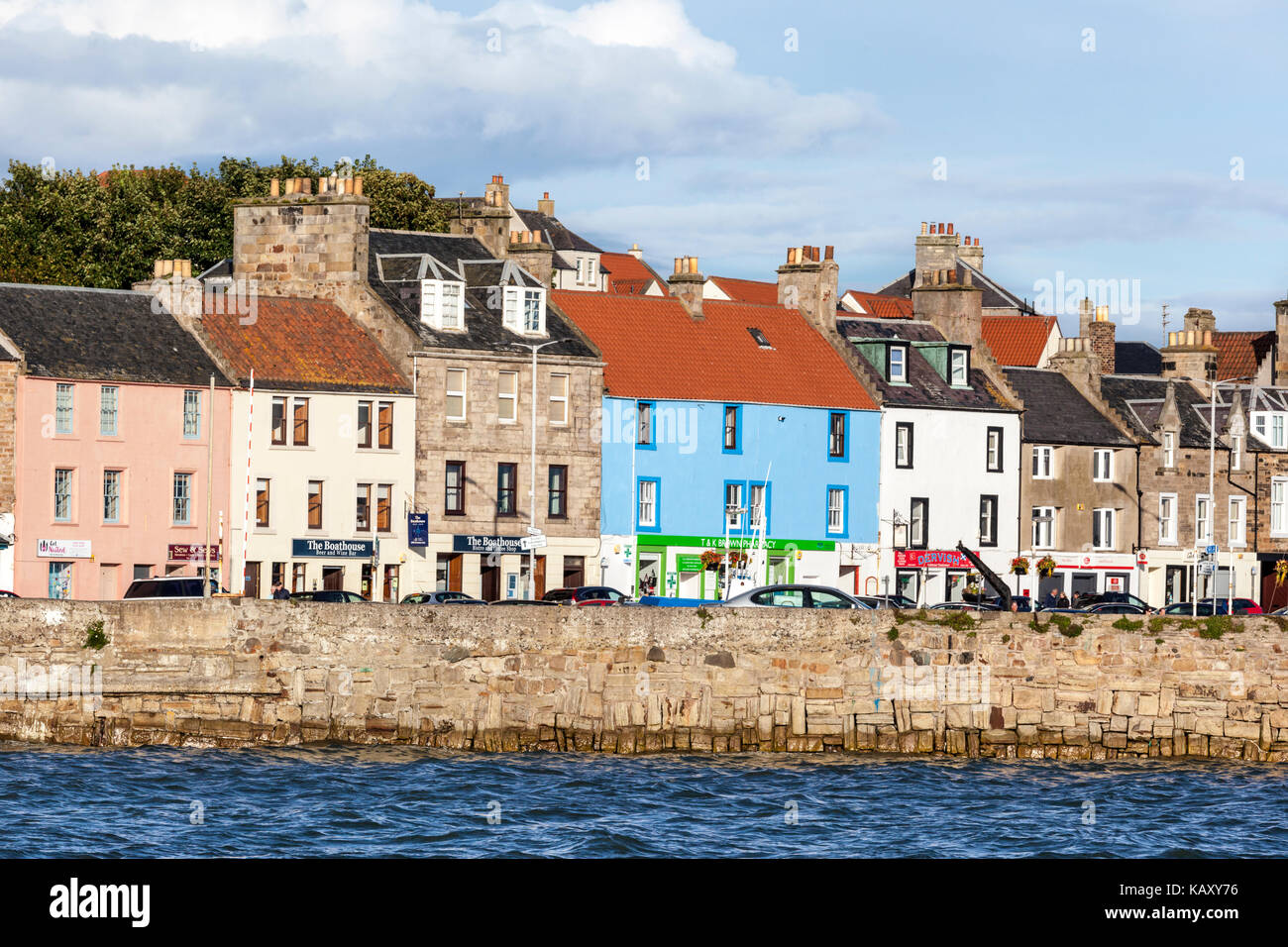 Evening light on traditional buildings on the seafront at high tide in ...