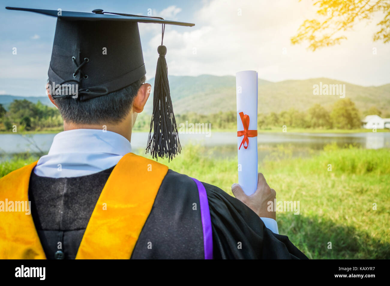 Graduate put he hands up and celebrating with certificate in he hand ...
