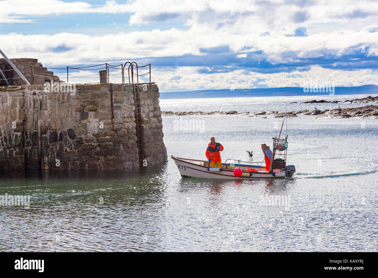 A lobster fishing boat entering the harbour at Crail, Fife, Scotland UK ...