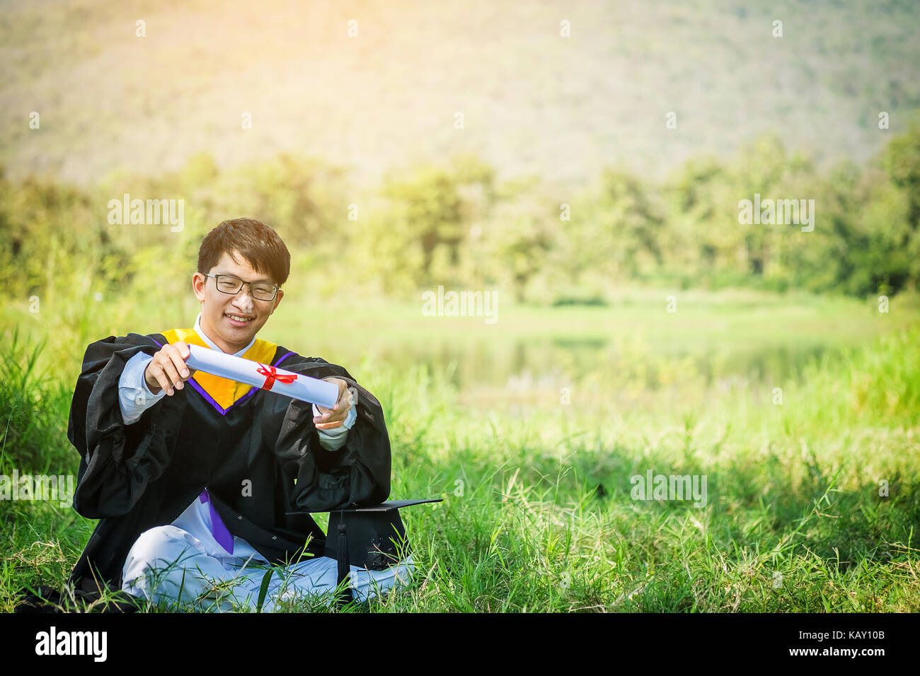 Graduation: Student sit and smile holding certificate, graduation hat ...