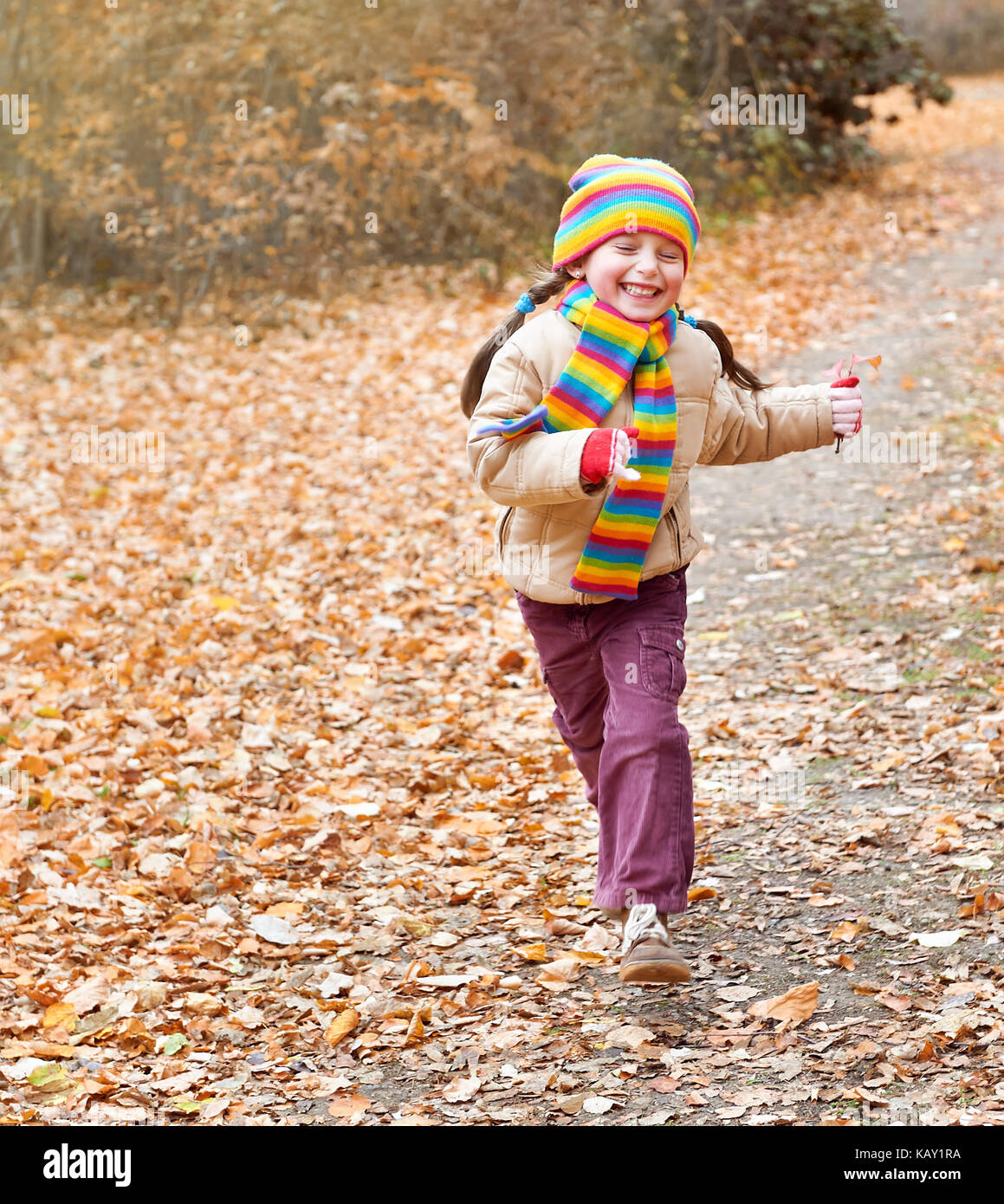 child girl runs on a path in forest, autumn leaves background, fall ...
