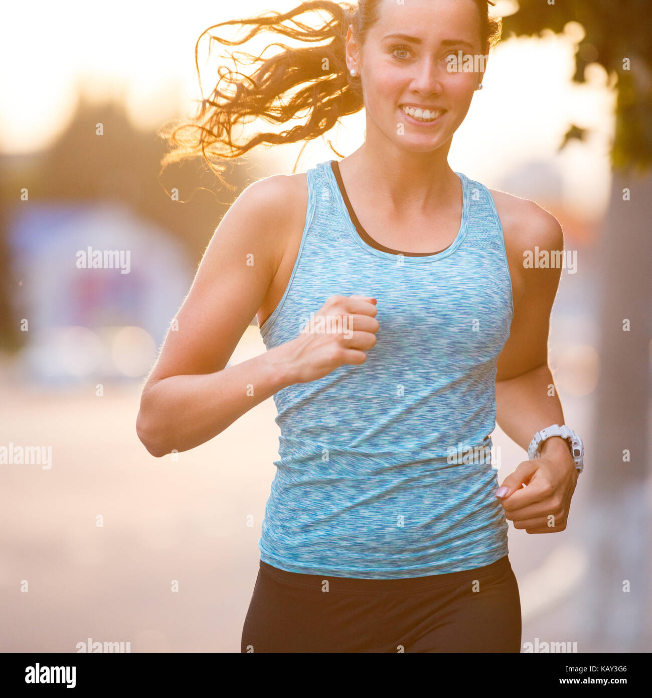 Young smiling sporty woman running on pavement in the morning. Fitness ...