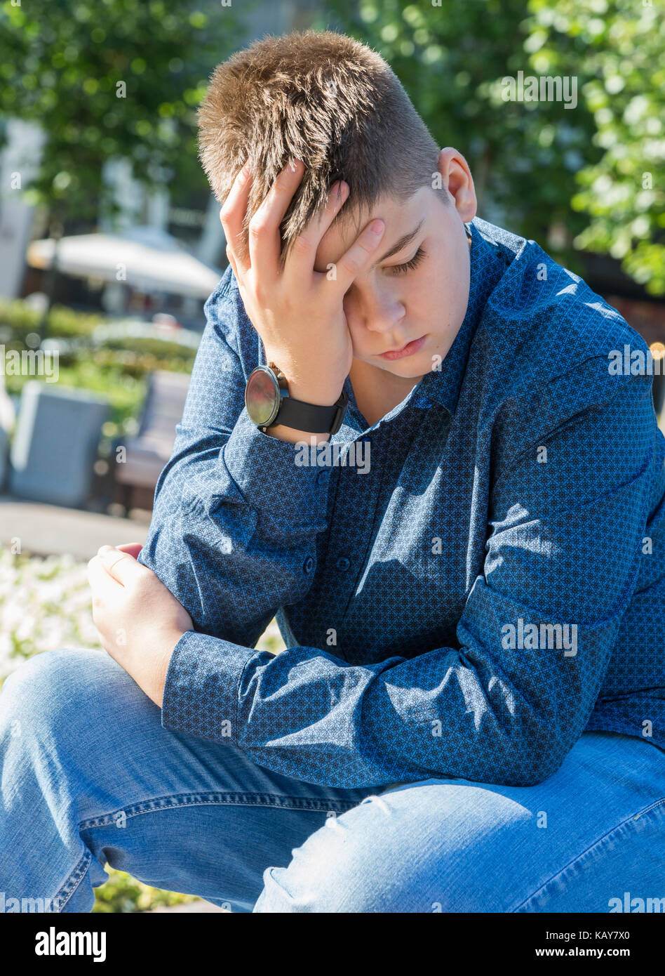Sad teenager sitting on street Stock Photo - Alamy