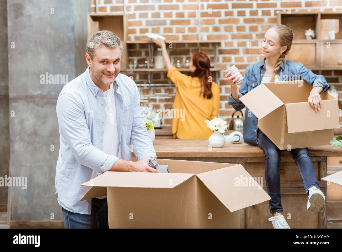 family unpacking cardboard boxes Stock Photo - Alamy