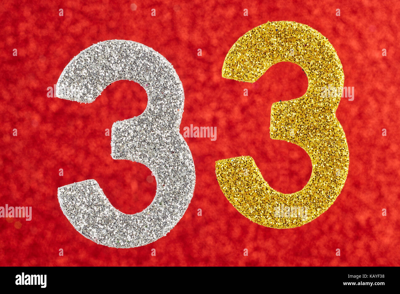 Number thirty-three yellow silver color over a red background ...