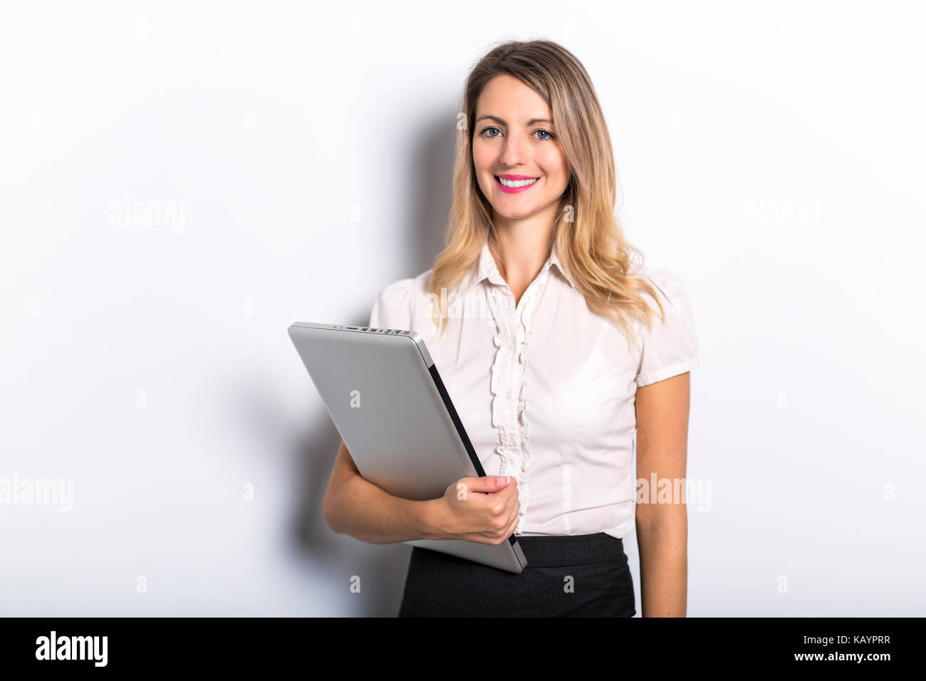 Young business woman offers computer product, on grey background Stock ...