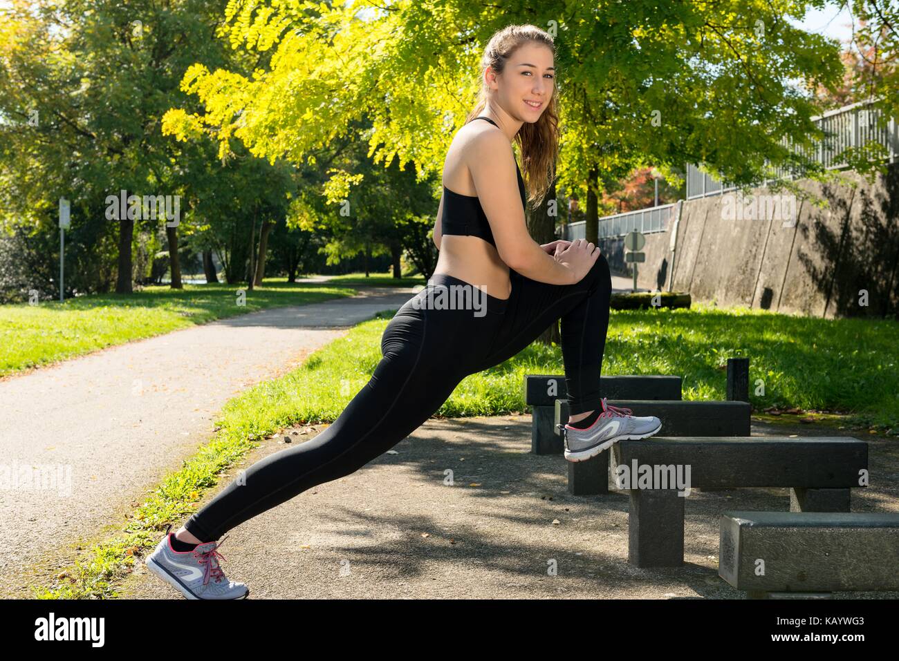 a side view of fit woman stretching and working out in the park Stock ...