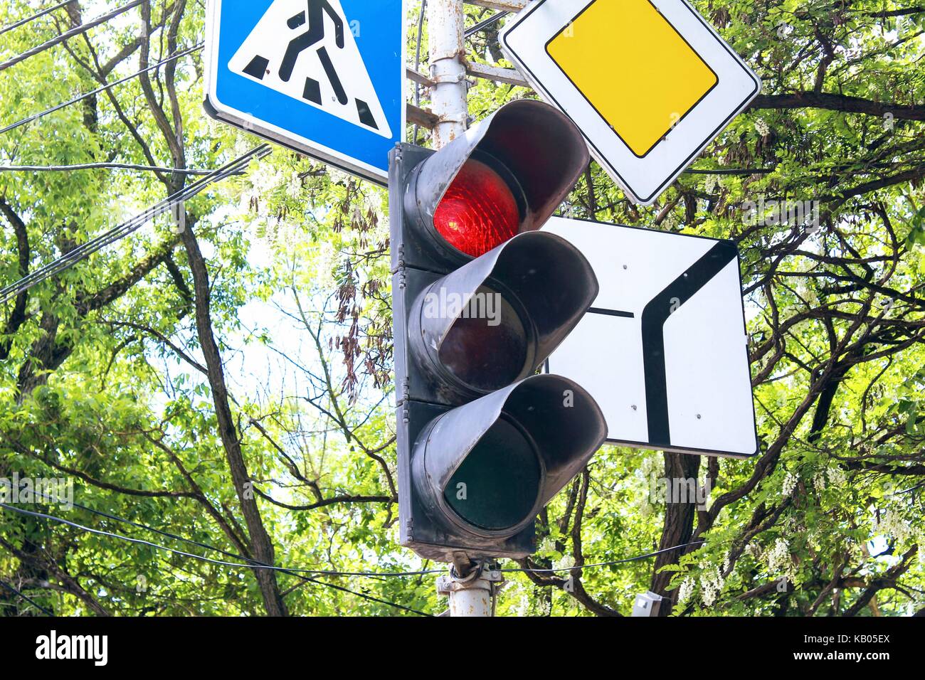Traffic light and three road signs regulating the traffic in the city ...