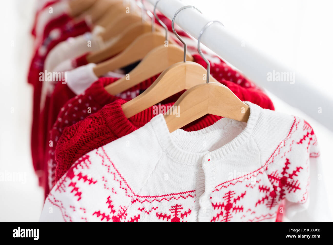 Clothes rack with red Christmas knit wear. Wardrobe with knitted winter ...