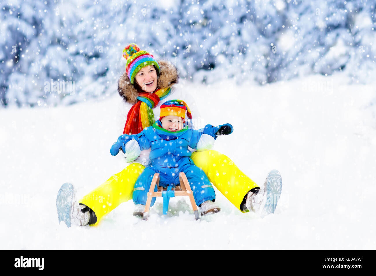 Mother and baby on sleigh ride. Child and mom sledding. Toddler kid ...