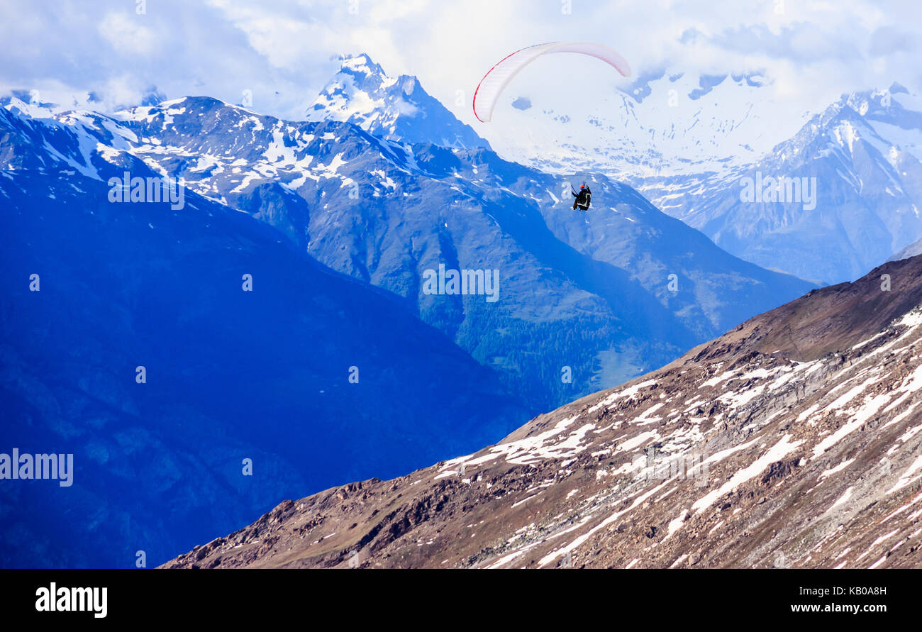 Paraglider flying over mountains in the summer day sky, Paragliding ...