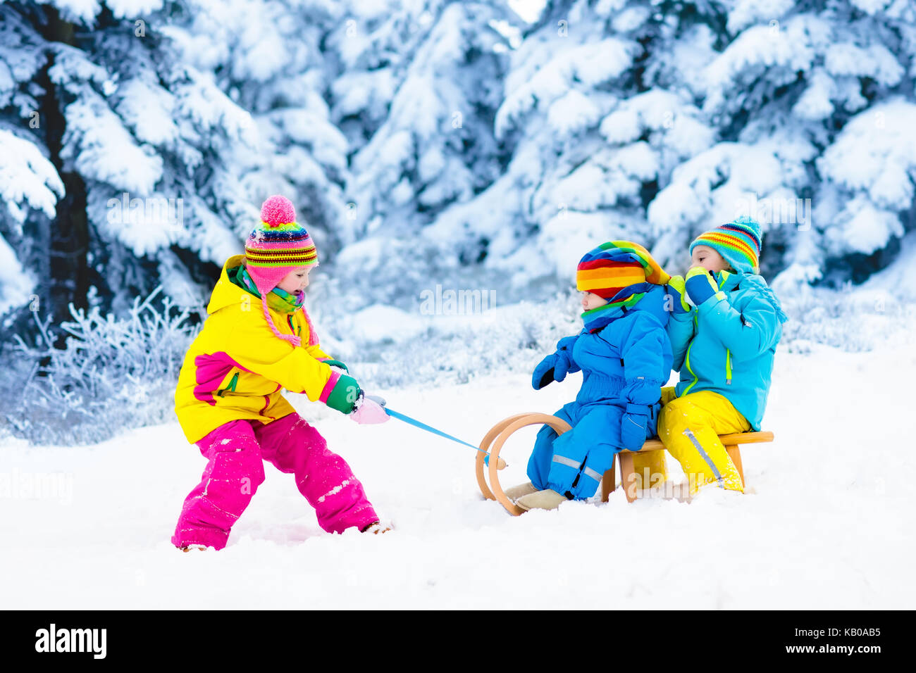 Little girl and boy enjoy a sleigh ride. Child sledding. Toddler kid ...