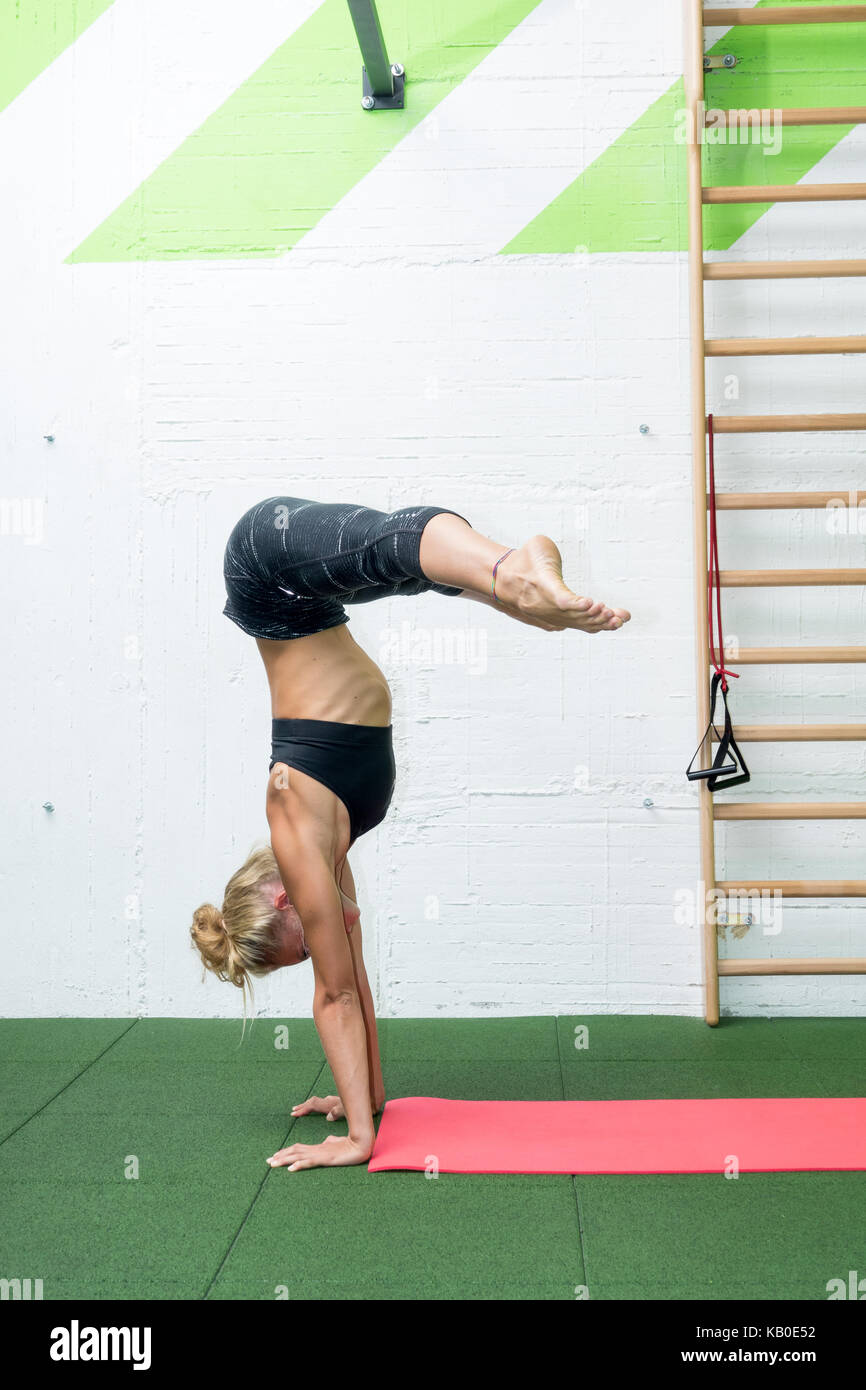 Fitness girl stretching legs doing pilates leg stretches exercises in ...