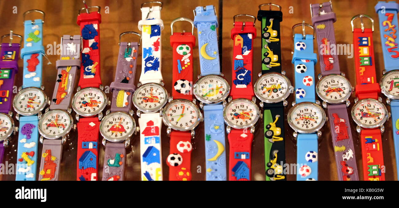 Selection of brightly coloured childrens watches arranged in a shop ...