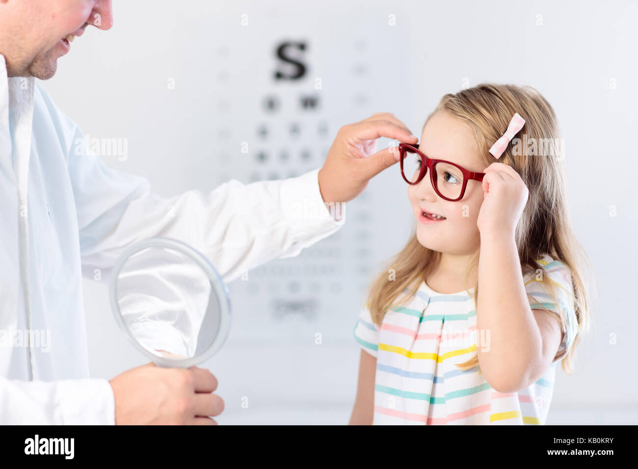 Child at eye sight test. Little kid selecting glasses at optician store ...