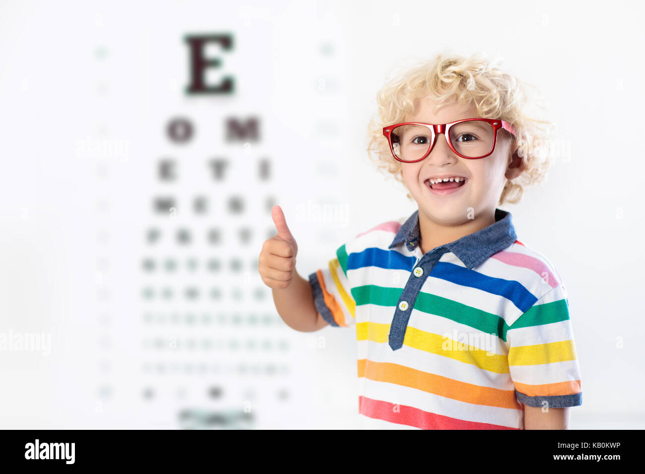Child at eye sight test. Little kid selecting glasses at optician store ...
