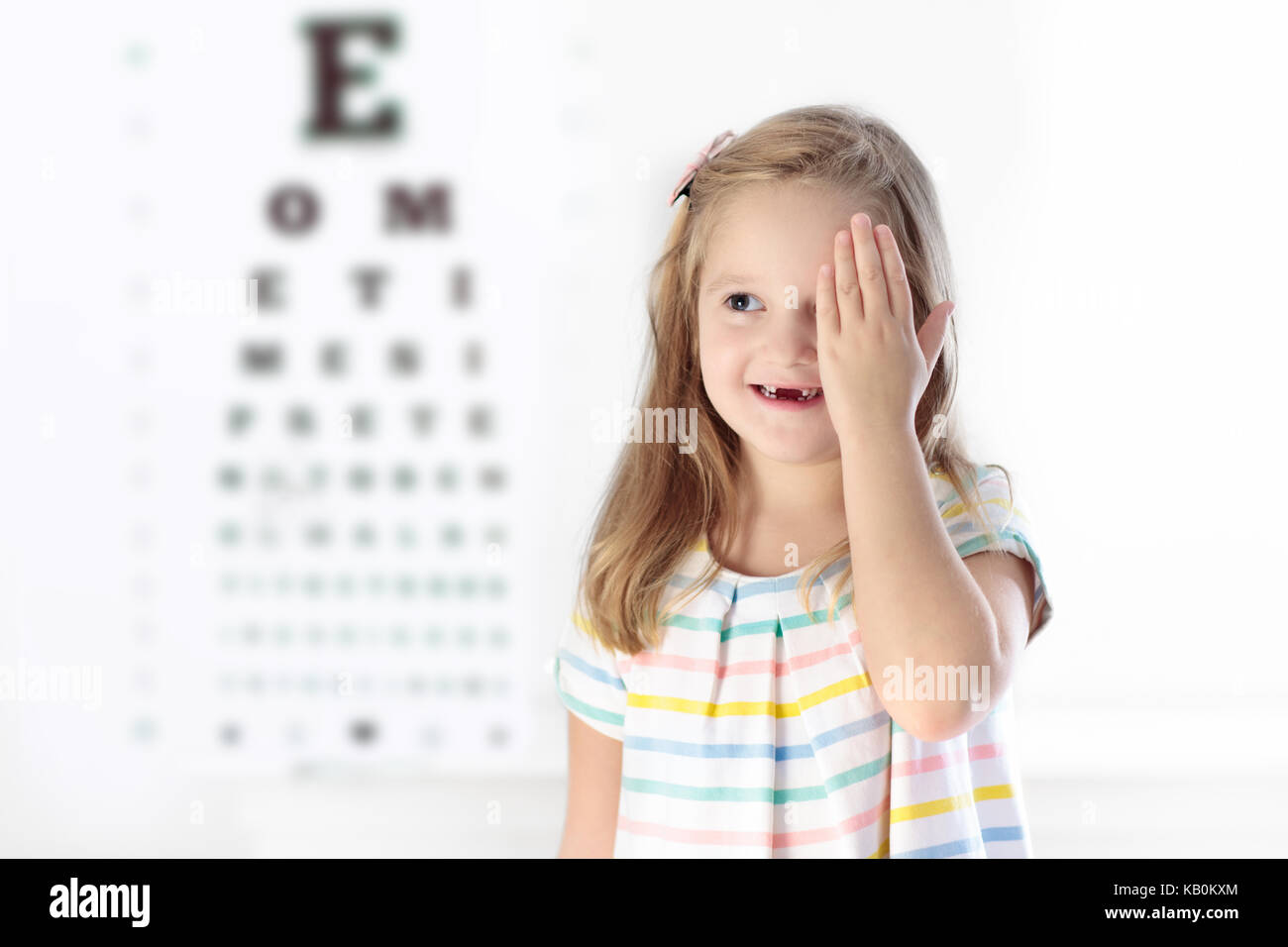 Child at eye sight test. Little kid selecting glasses at optician store ...