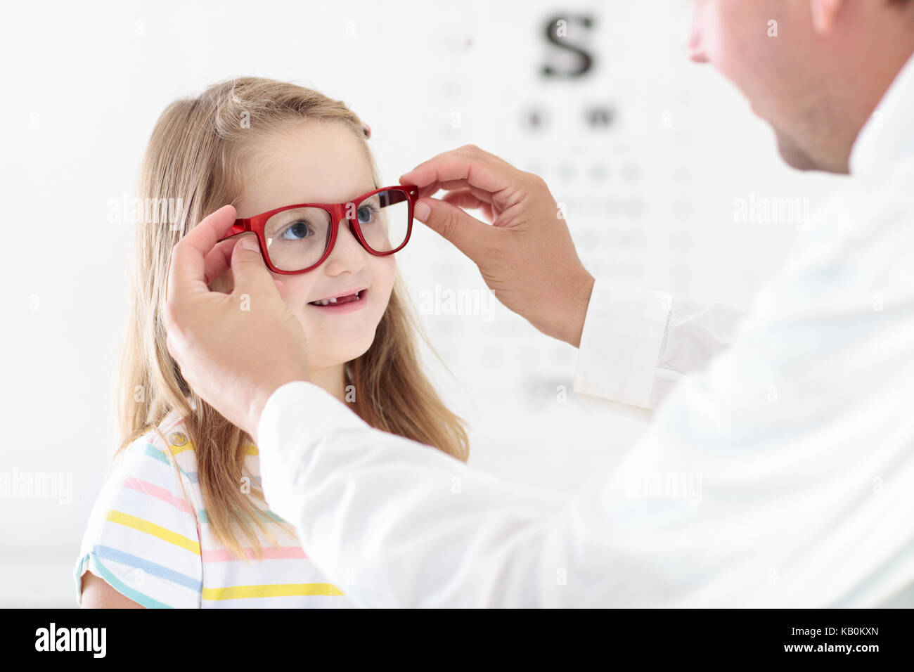 Child at eye sight test. Little kid selecting glasses at optician store ...