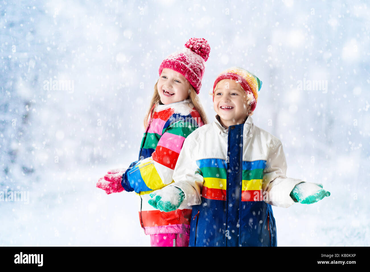 Kids playing in snow. Children play outdoors on snowy winter day. Boy ...