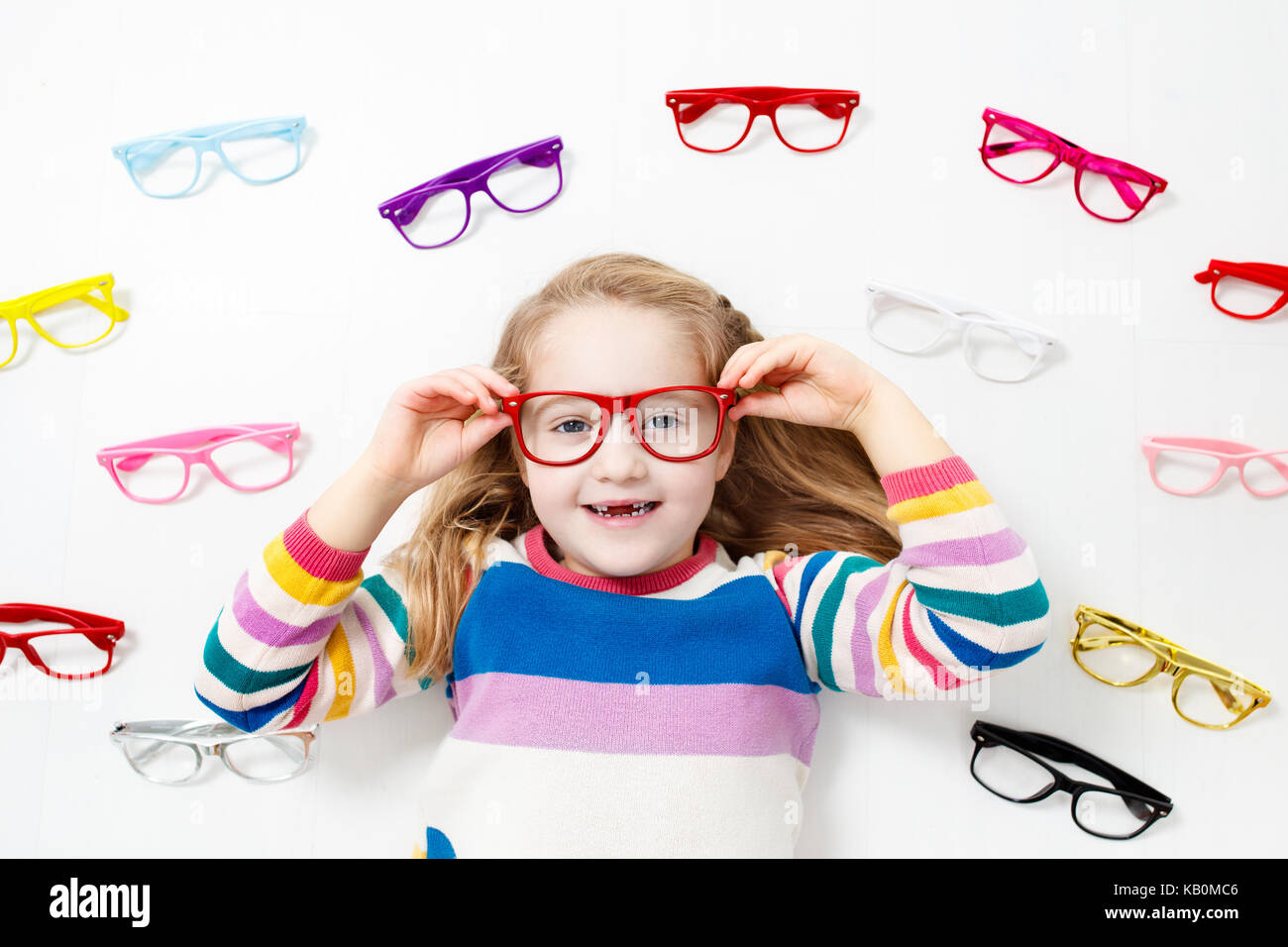 Child at eye sight test. Little kid selecting glasses at optician store ...