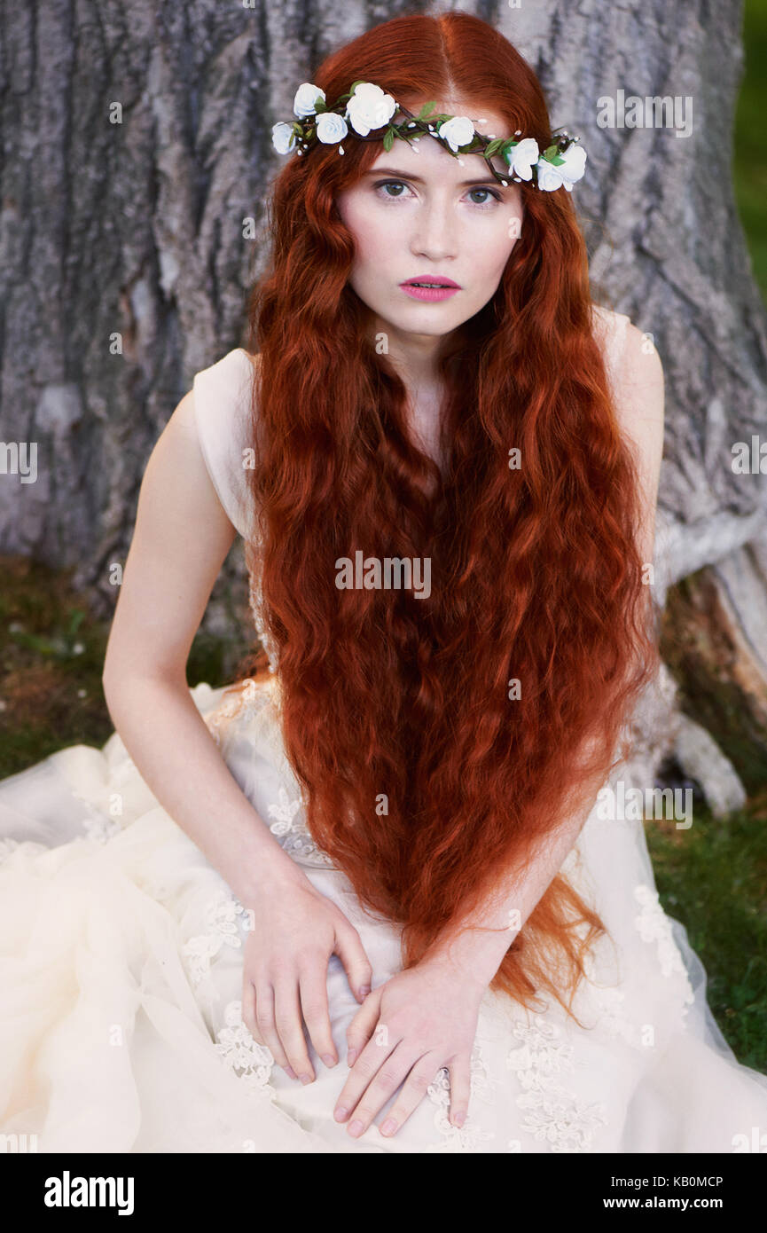 Portrait of a beautiful redheaded girl with long curly hair. Bride ...