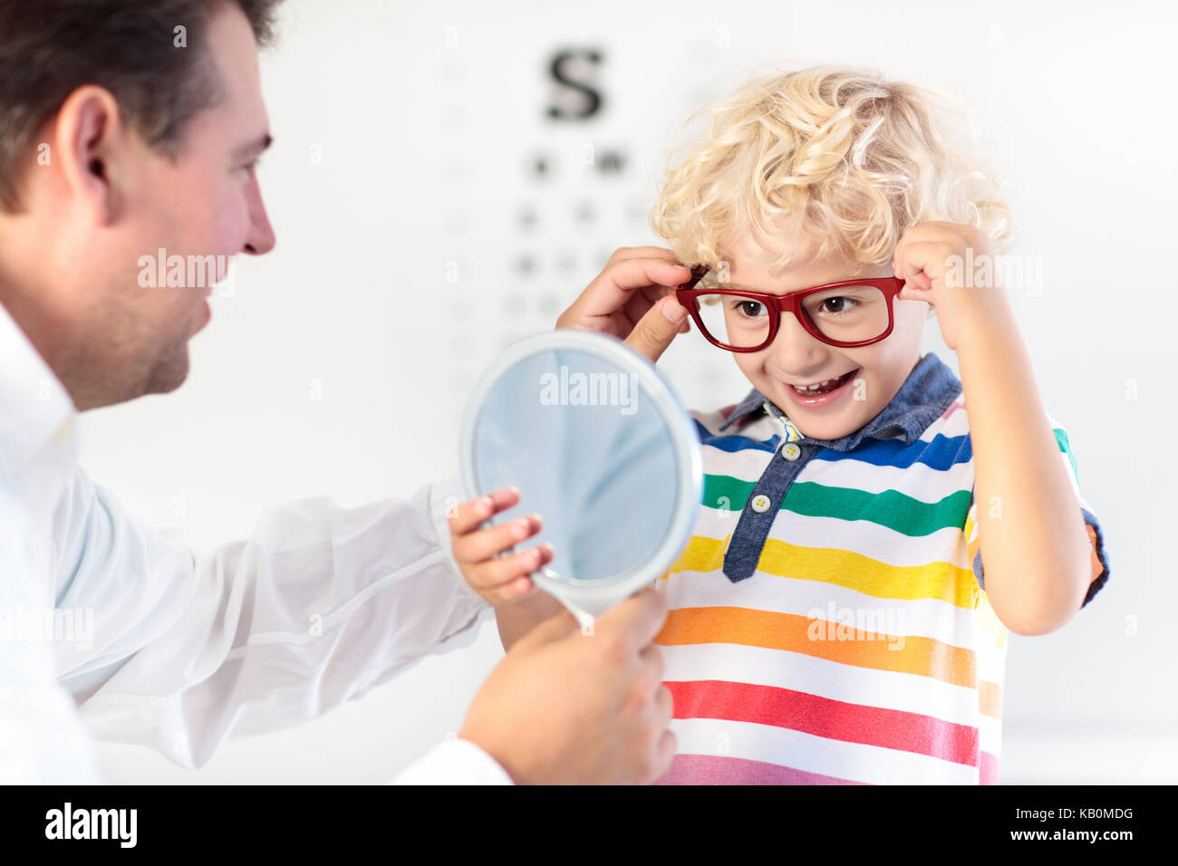 Child at eye sight test. Little kid selecting glasses at optician store ...