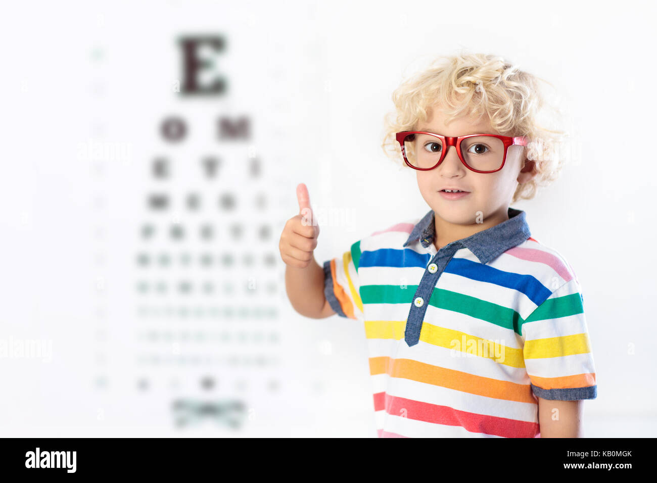 Child at eye sight test. Little kid selecting glasses at optician store ...