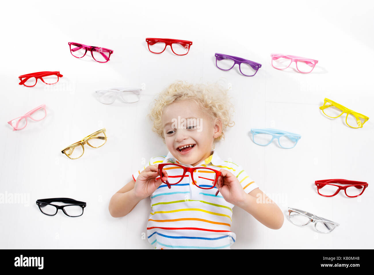 Child at eye sight test. Little kid selecting glasses at optician store ...