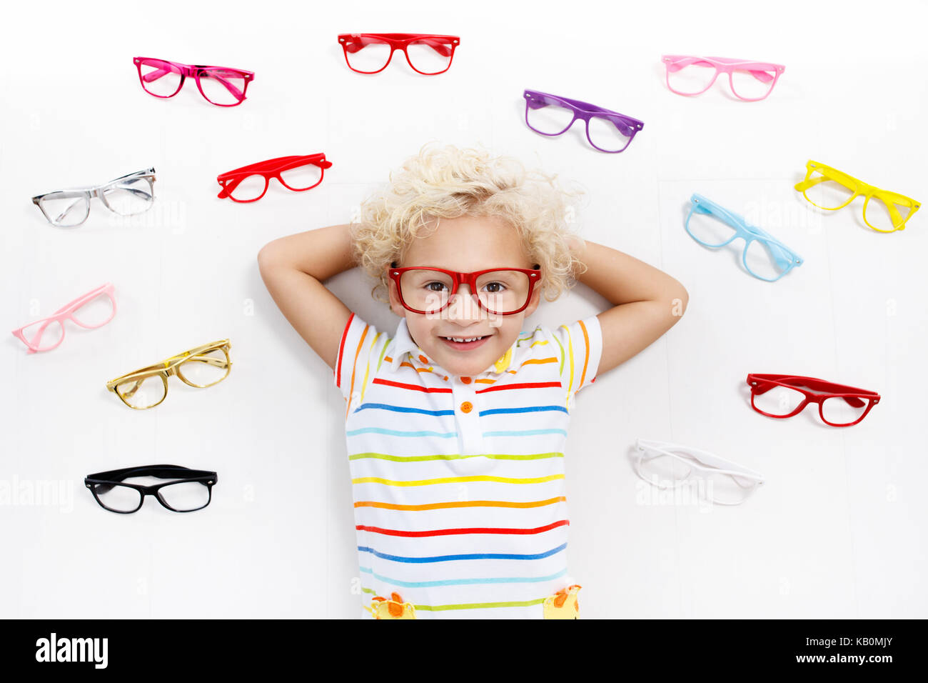 Child at eye sight test. Little kid selecting glasses at optician store ...