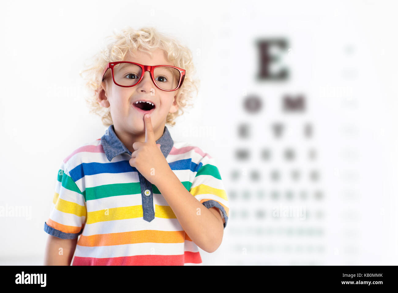 Child at eye sight test. Little kid selecting glasses at optician store ...
