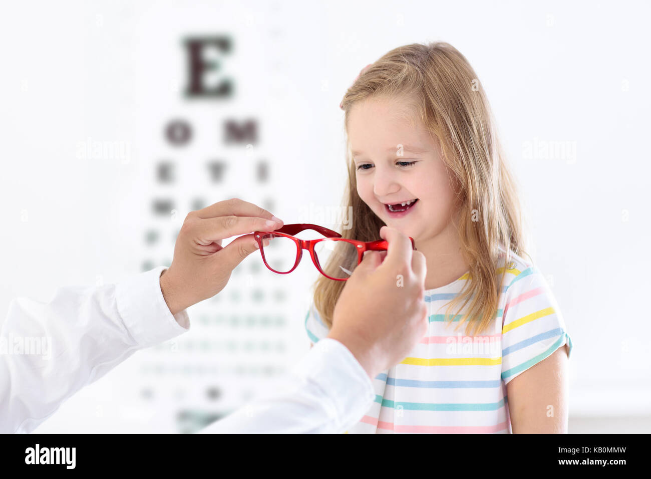 Child at eye sight test. Little kid selecting glasses at optician store ...